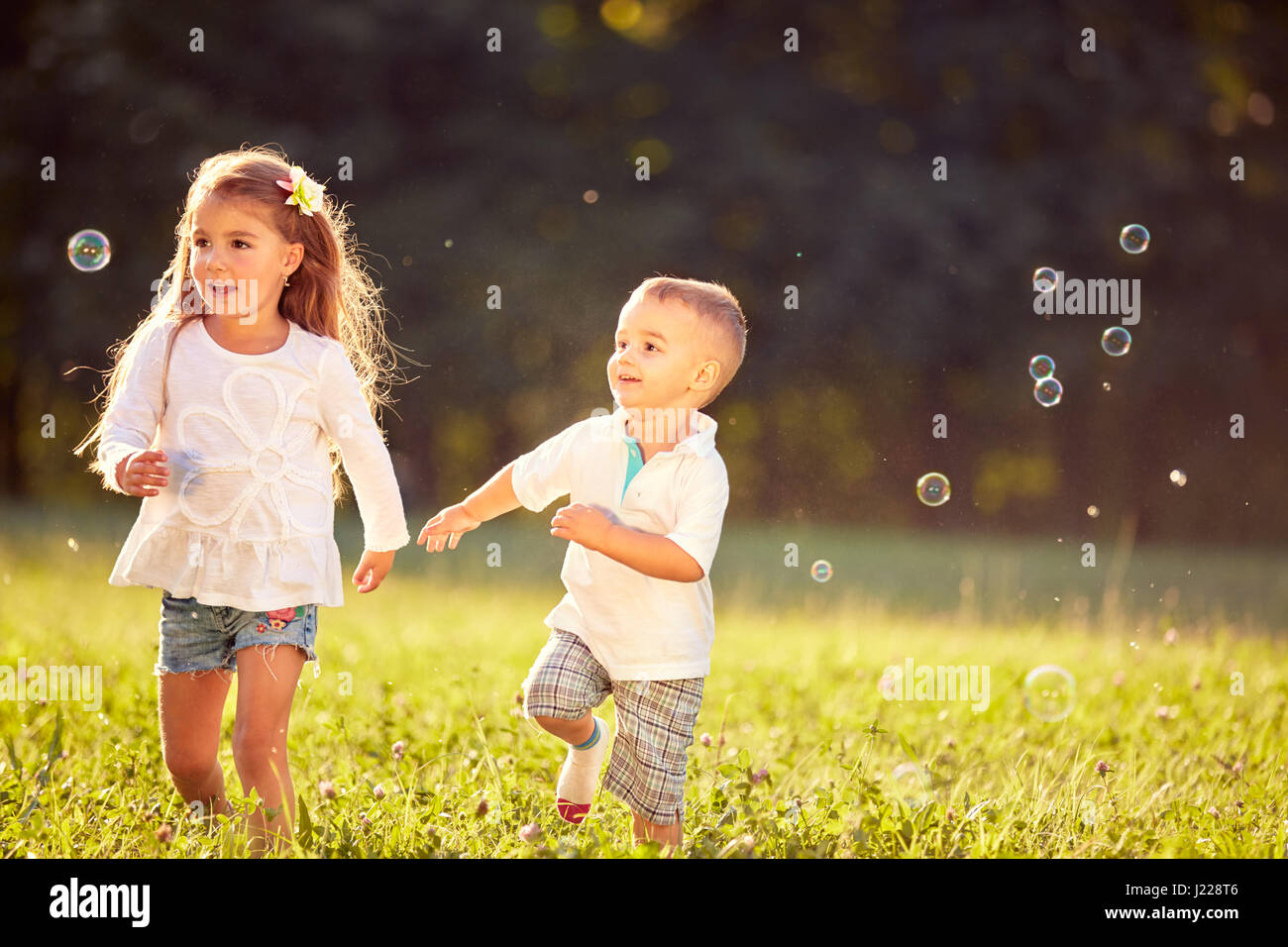 Cheerful children running together outside Stock Photo - Alamy