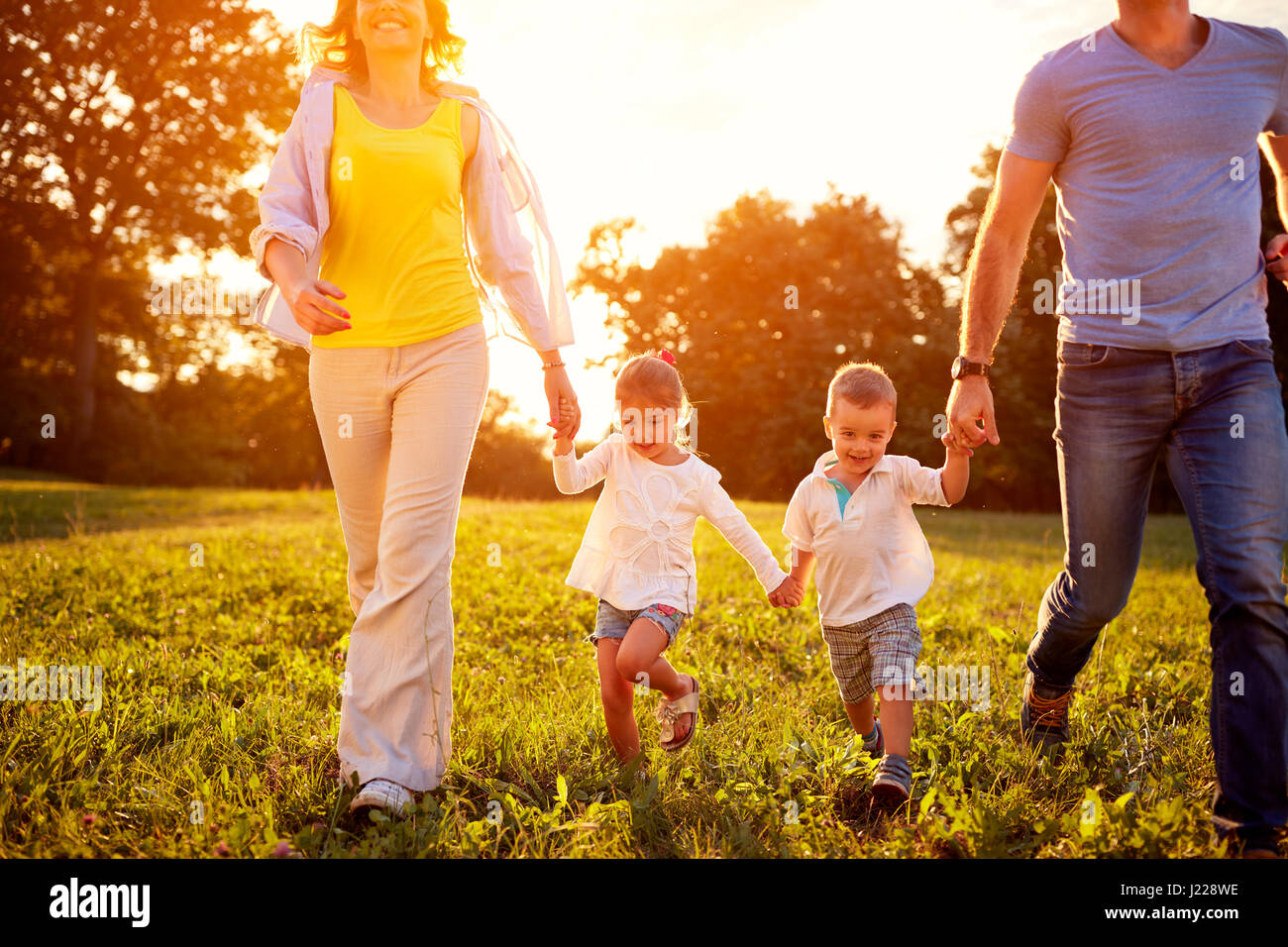 Cute girl and boy with parents in walk outdoor Stock Photo - Alamy