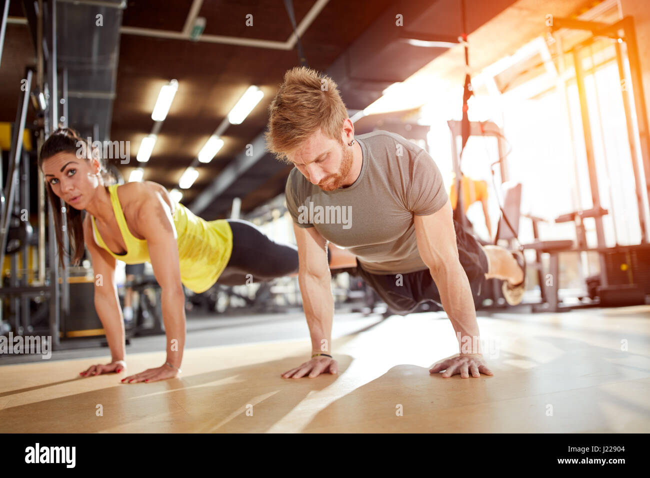 Woman with coach doing hard exercise in gym Stock Photo - Alamy