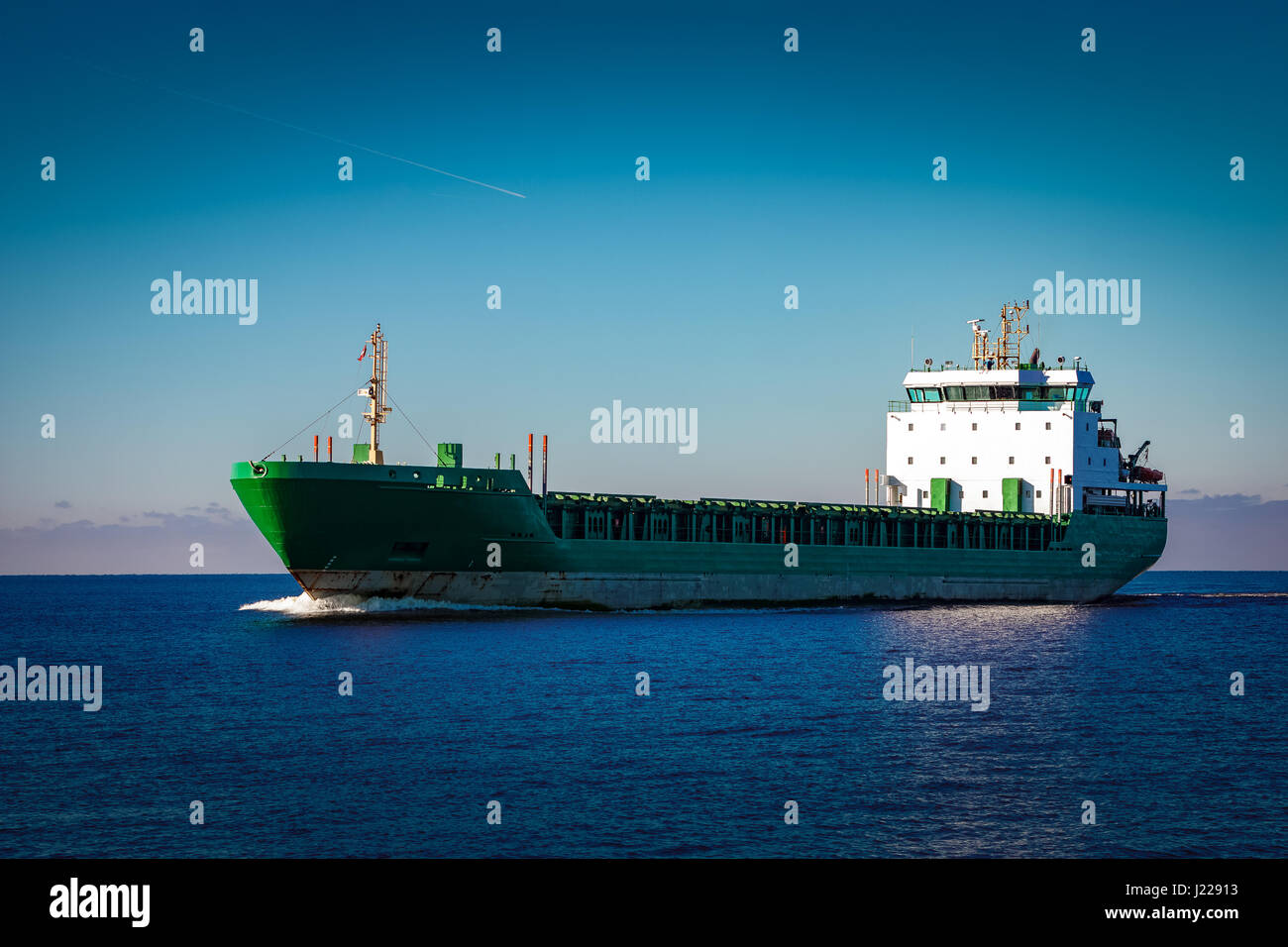 Green cargo ship moving in still water of Baltic sea Stock Photo - Alamy