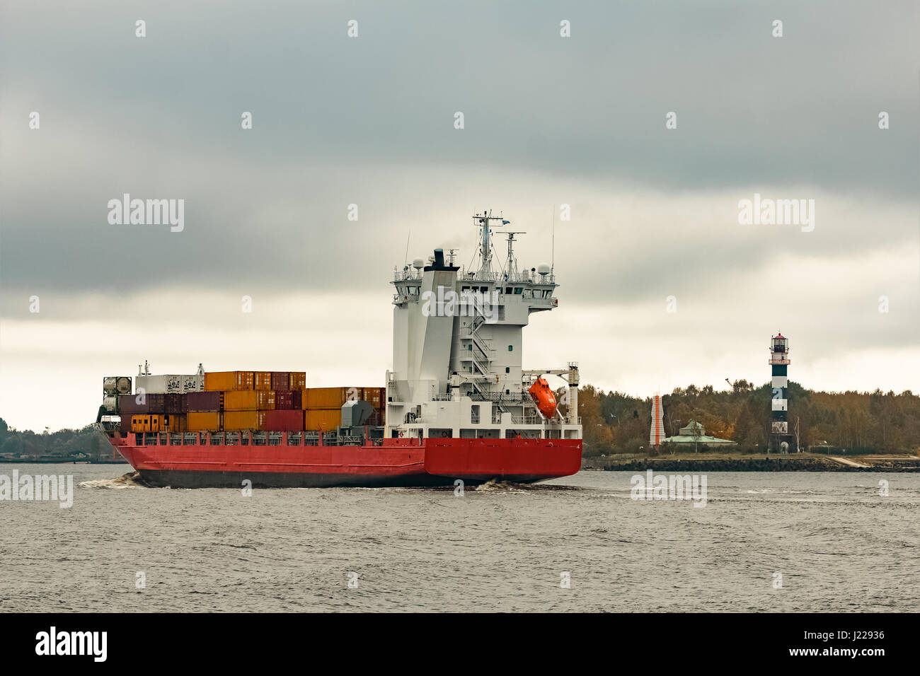 Red cargo container ship entering the port of Riga in cloudy day Stock ...