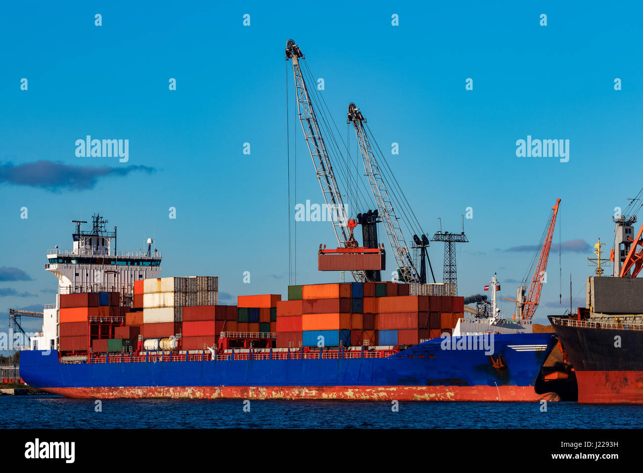 Blue container ship loading in cargo port of Europe Stock Photo - Alamy