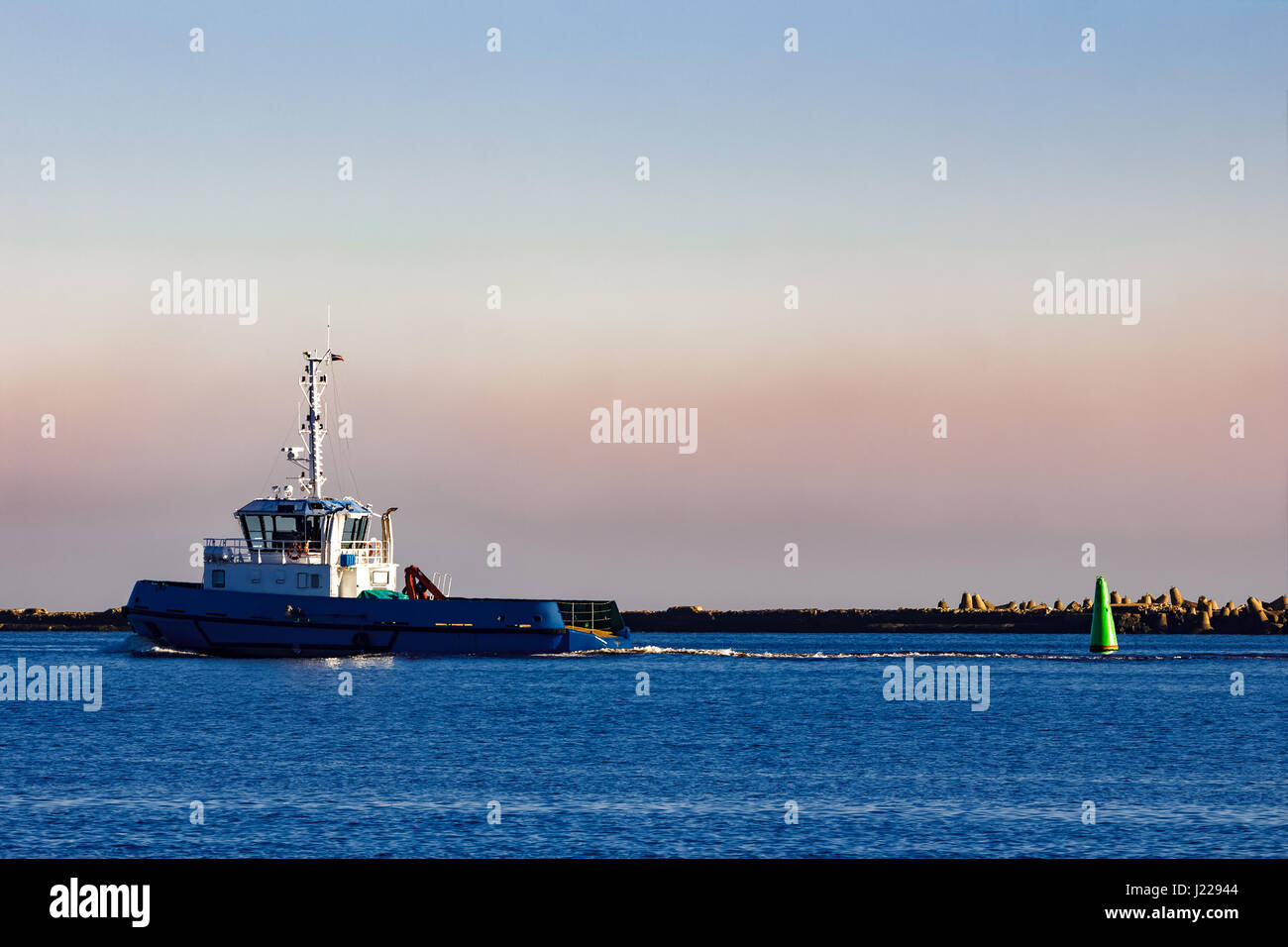 Blue small tug ship leaving Riga and entering the Baltic sea Stock ...