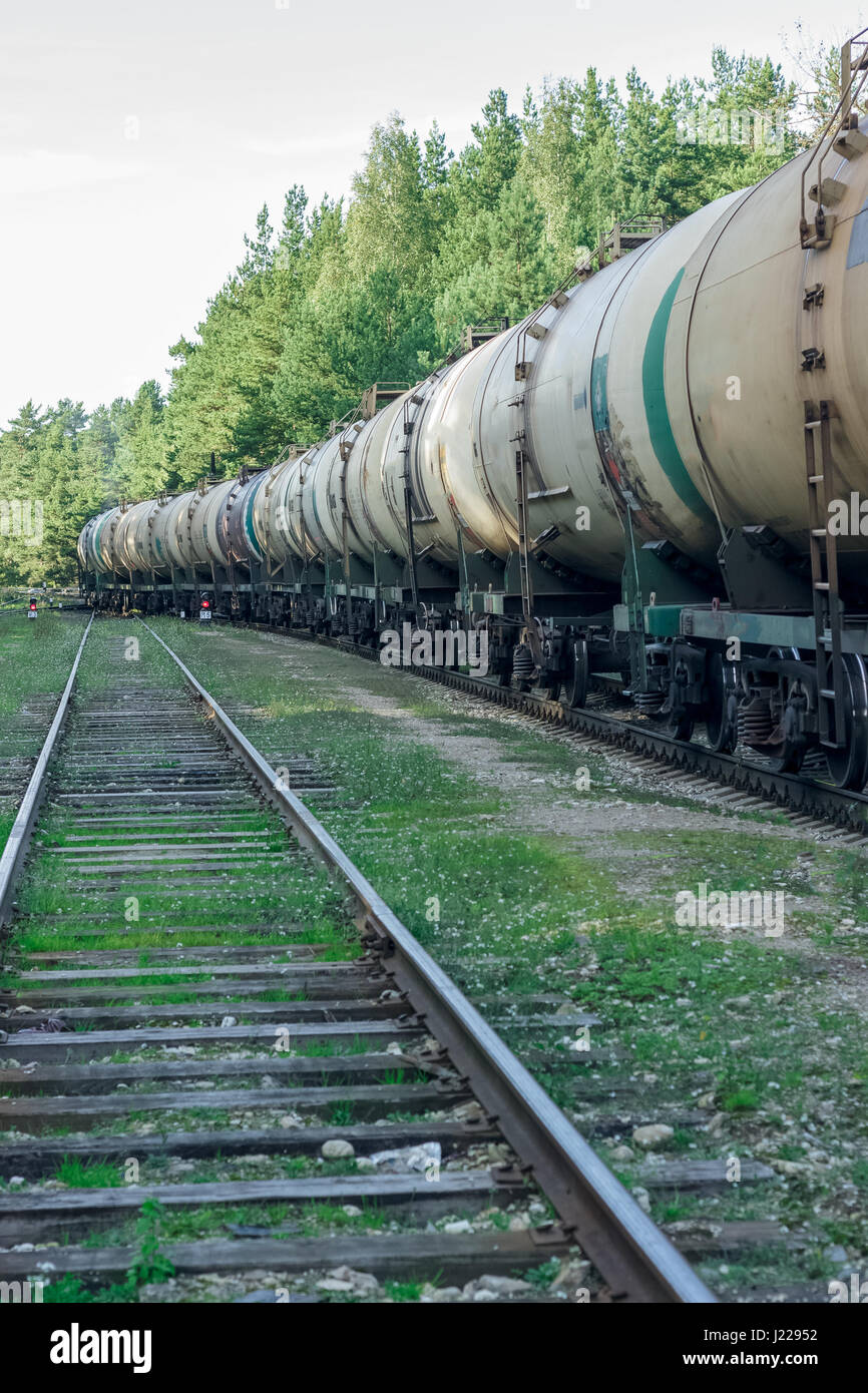 Tank wagons with oil. Freight train in forest Stock Photo - Alamy