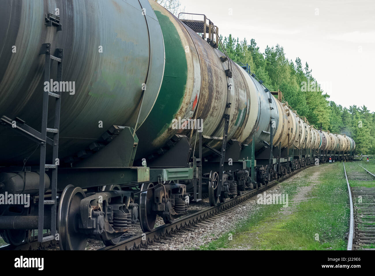 Tank wagons with oil. Freight train in forest Stock Photo - Alamy