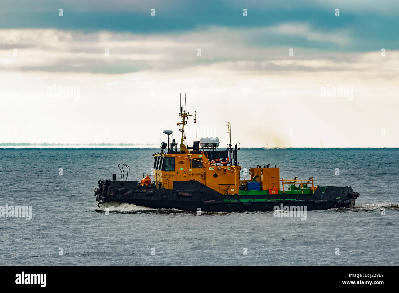 Small orange tug ship moving from the Baltic sea Stock Photo - Alamy