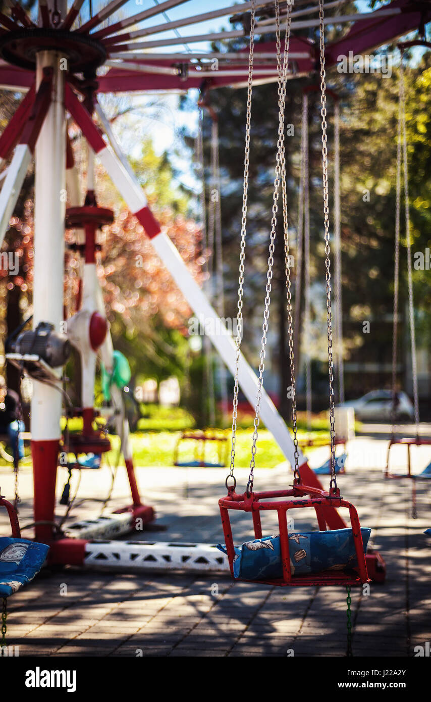 View on carousel seats, during spring sunny day Stock Photo - Alamy