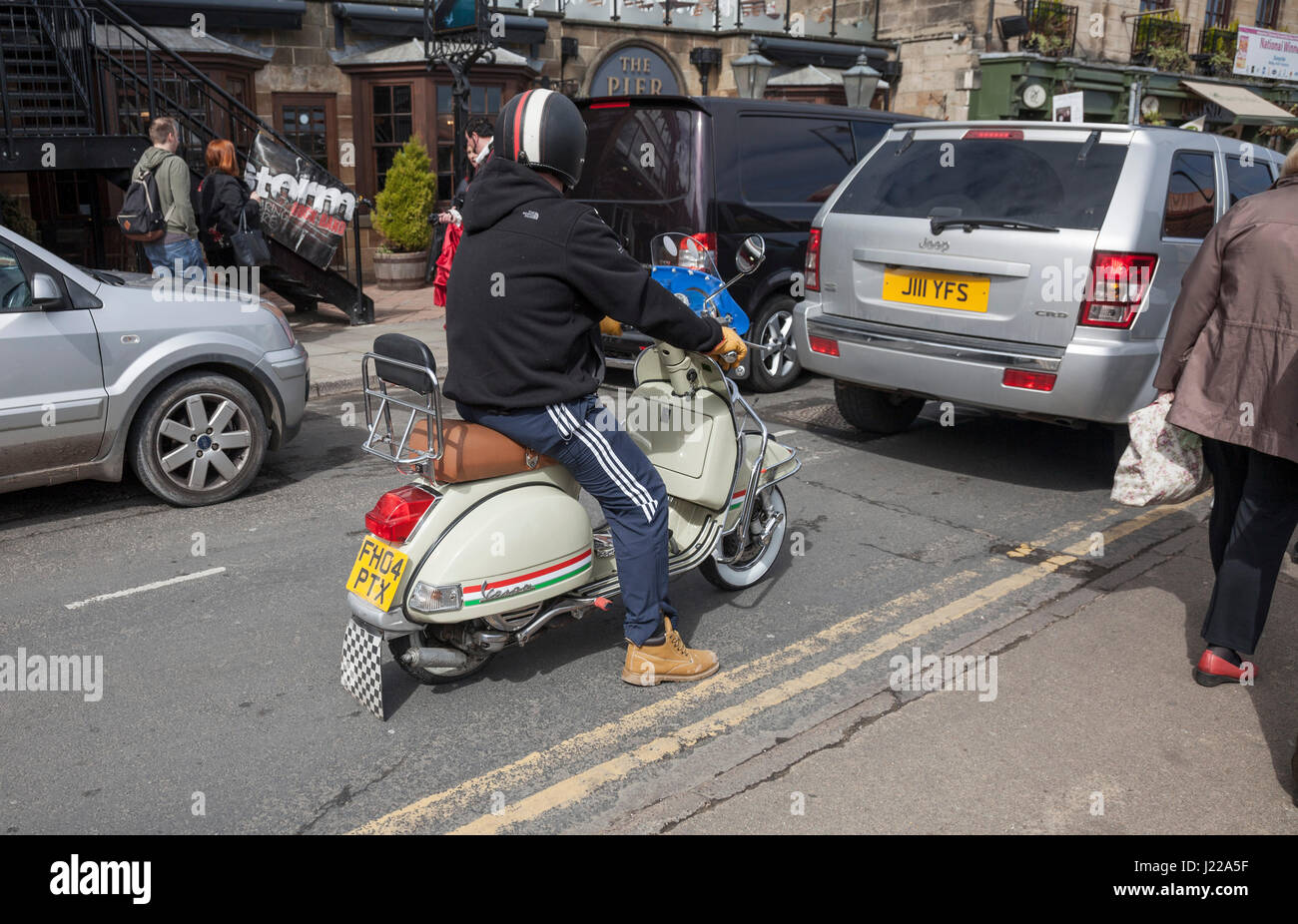 A man riding a Vespa scooter along the harbour rioad at Whitby,North ...