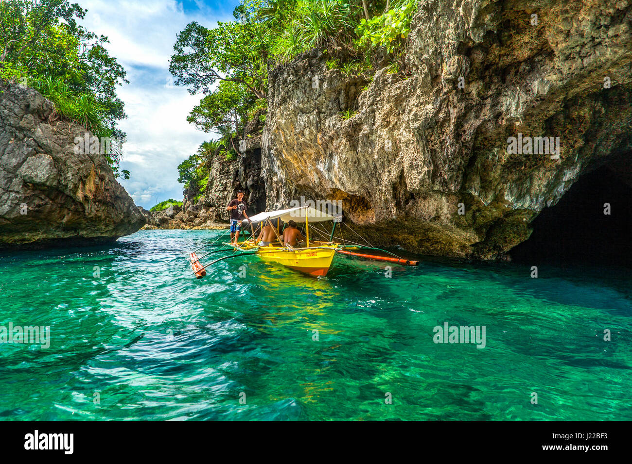 A pontoon boat sails on emerald green water in the Panay Gulf, Guimaras ...