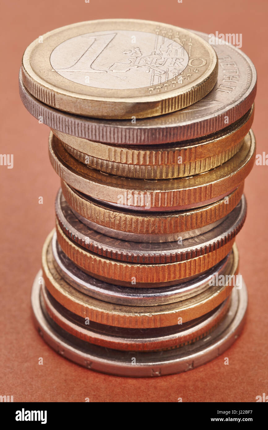 Different kinds of coins over a red background. Macro detail. Vertical ...