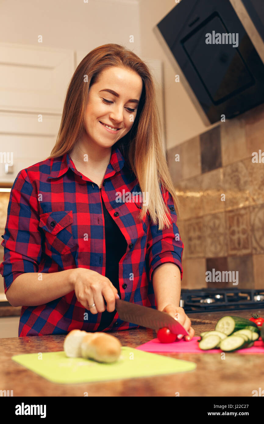 Young woman chopping vegetables in the kitchen Stock Photo - Alamy