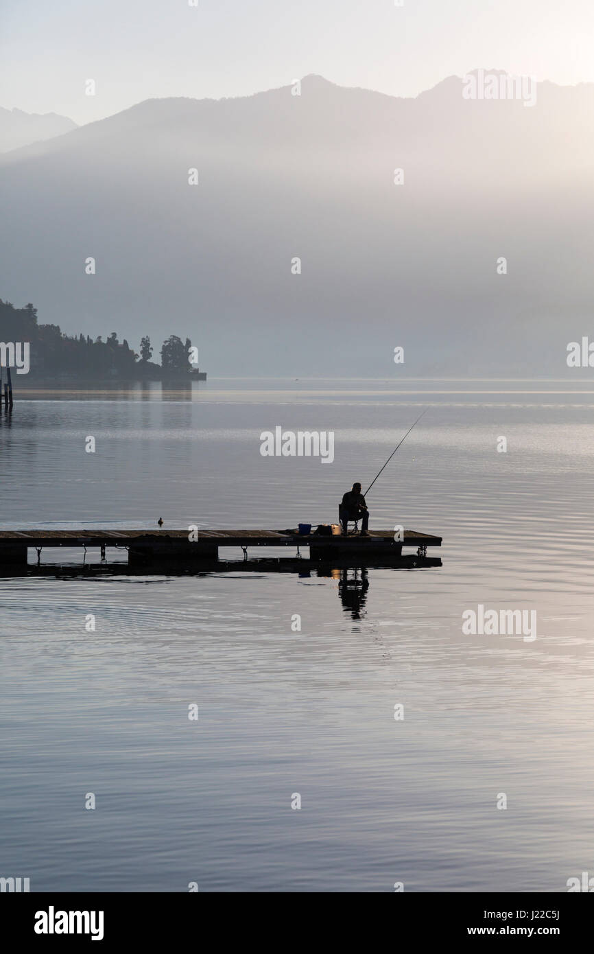 Lone fisherman on serene lake hi-res stock photography and images - Alamy