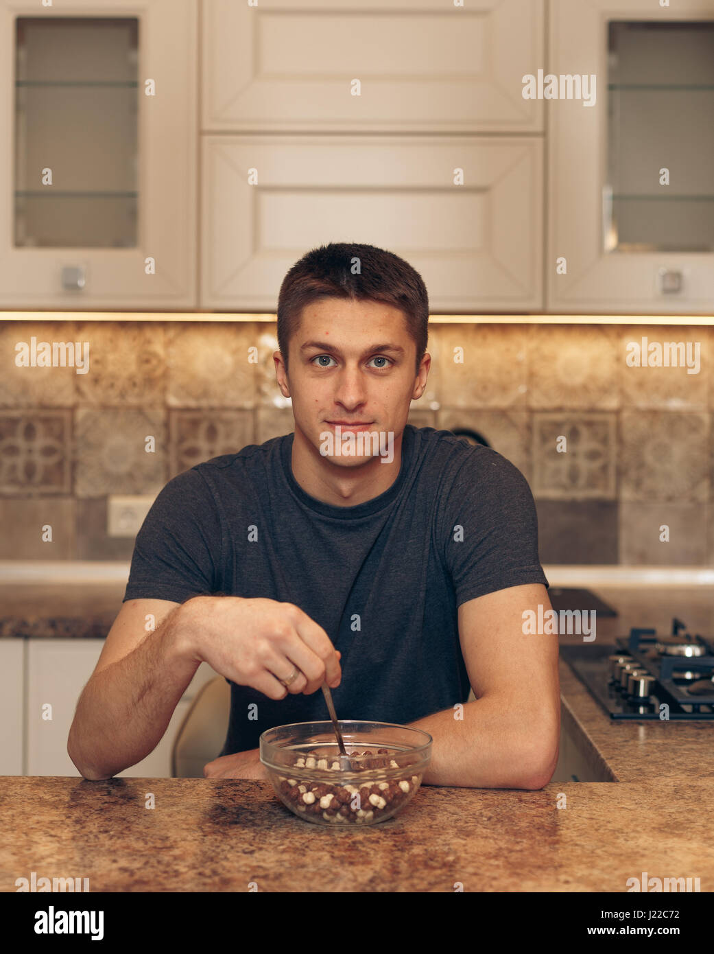 Young man eating morning breakfast Stock Photo - Alamy