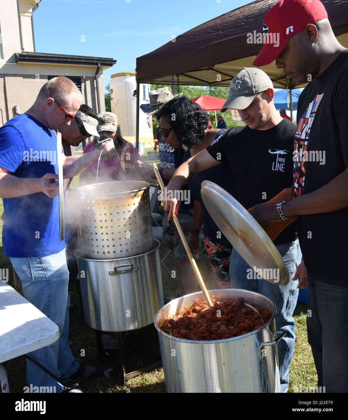 “Swamp Swimmers” team members lift freshly boiled crawfish from a pot ...