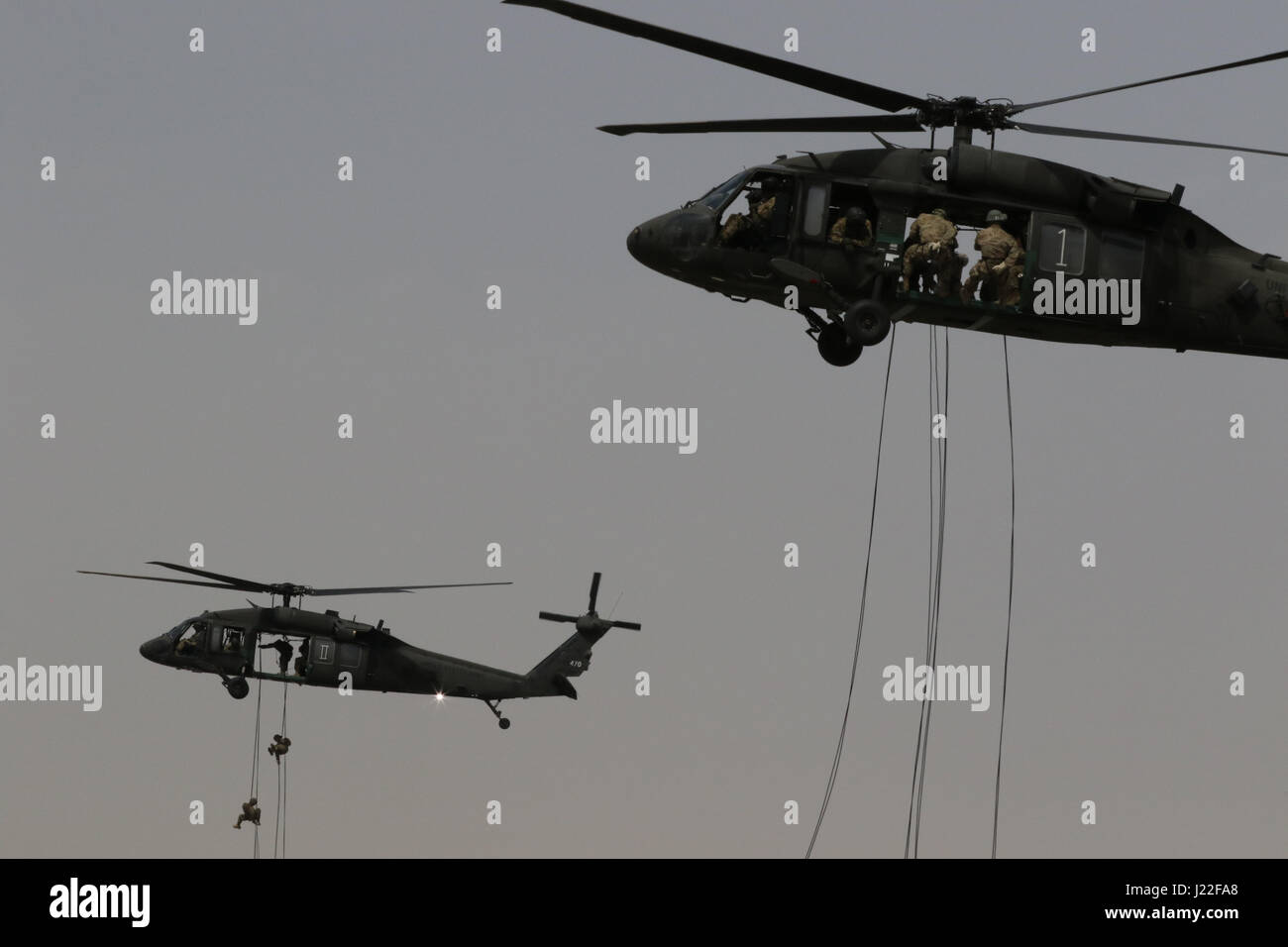 U.S. Servicemembers rappelling out of UH-60 Black Hawk helicopters ...