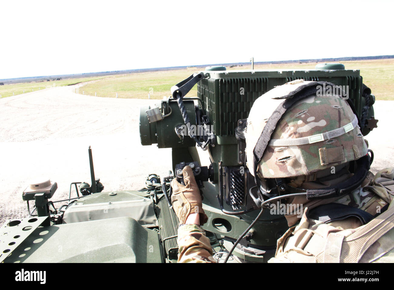A Battle Group Poland forward observer monitors the impact of artillery ...