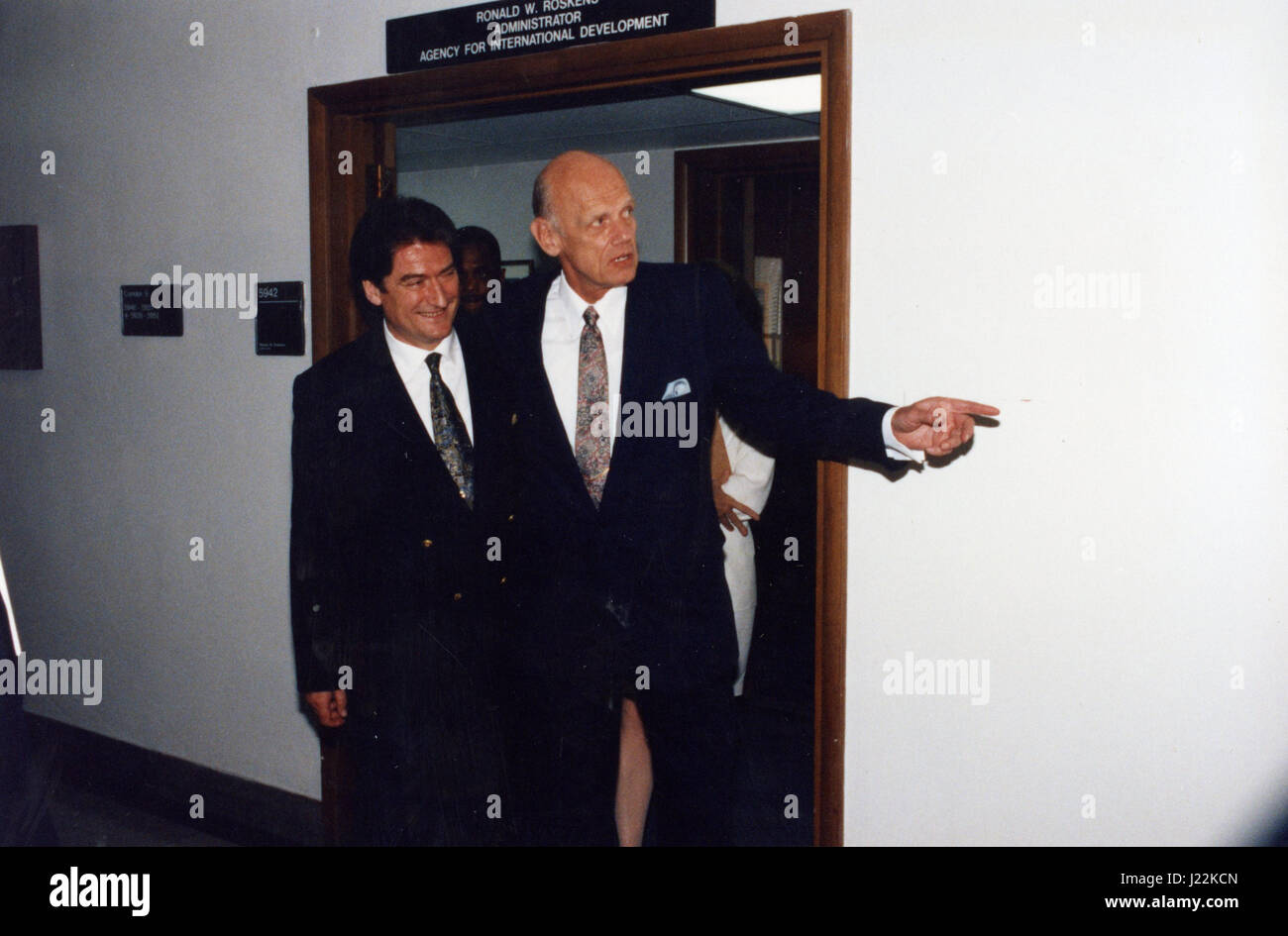 MAN GUIDING ANOTHER MAN TO ANOTHER ROOM Stock Photo - Alamy