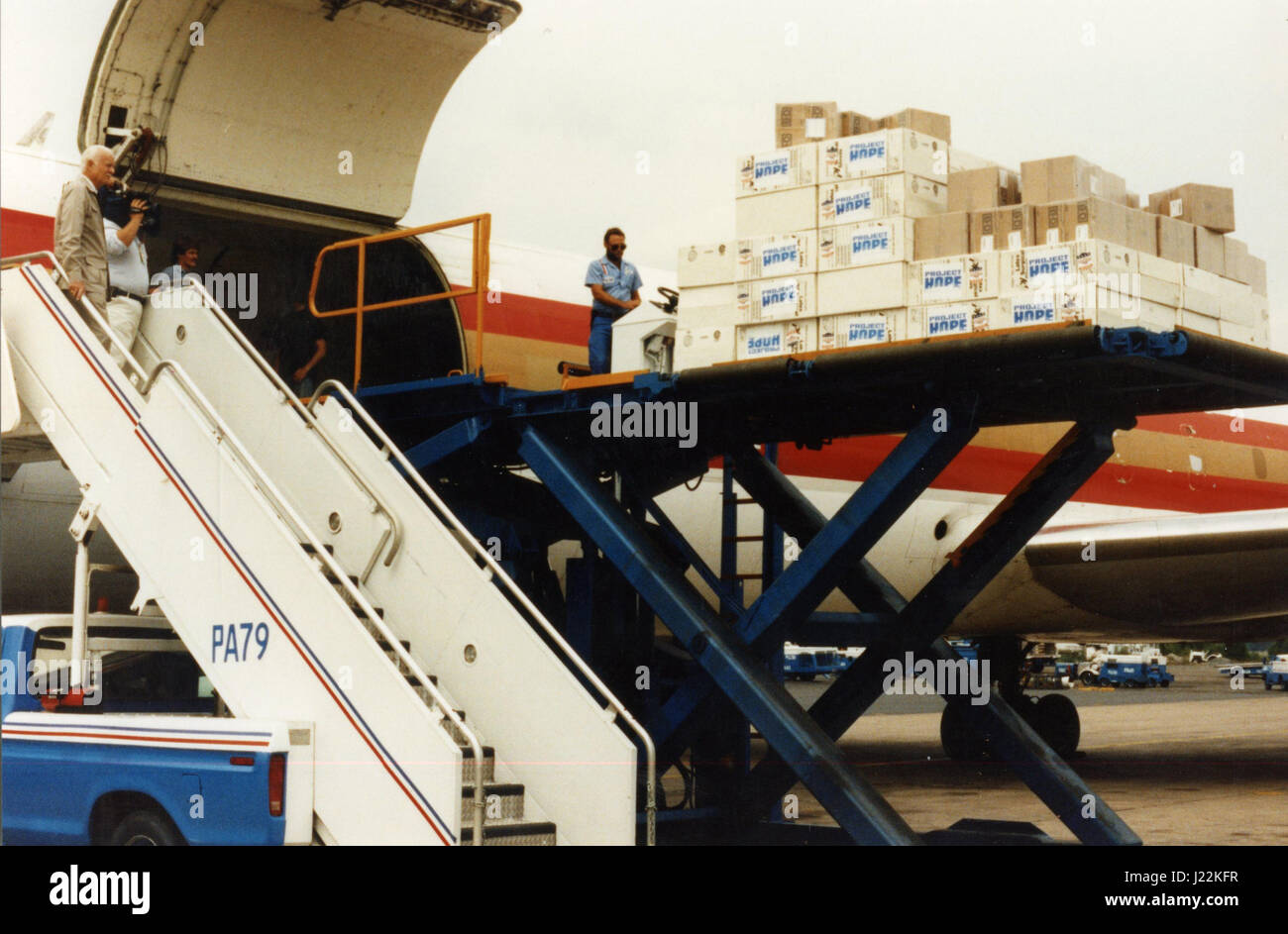 MAN LOADING BOXES OFF OF AN AIRPLANE Stock Photo - Alamy