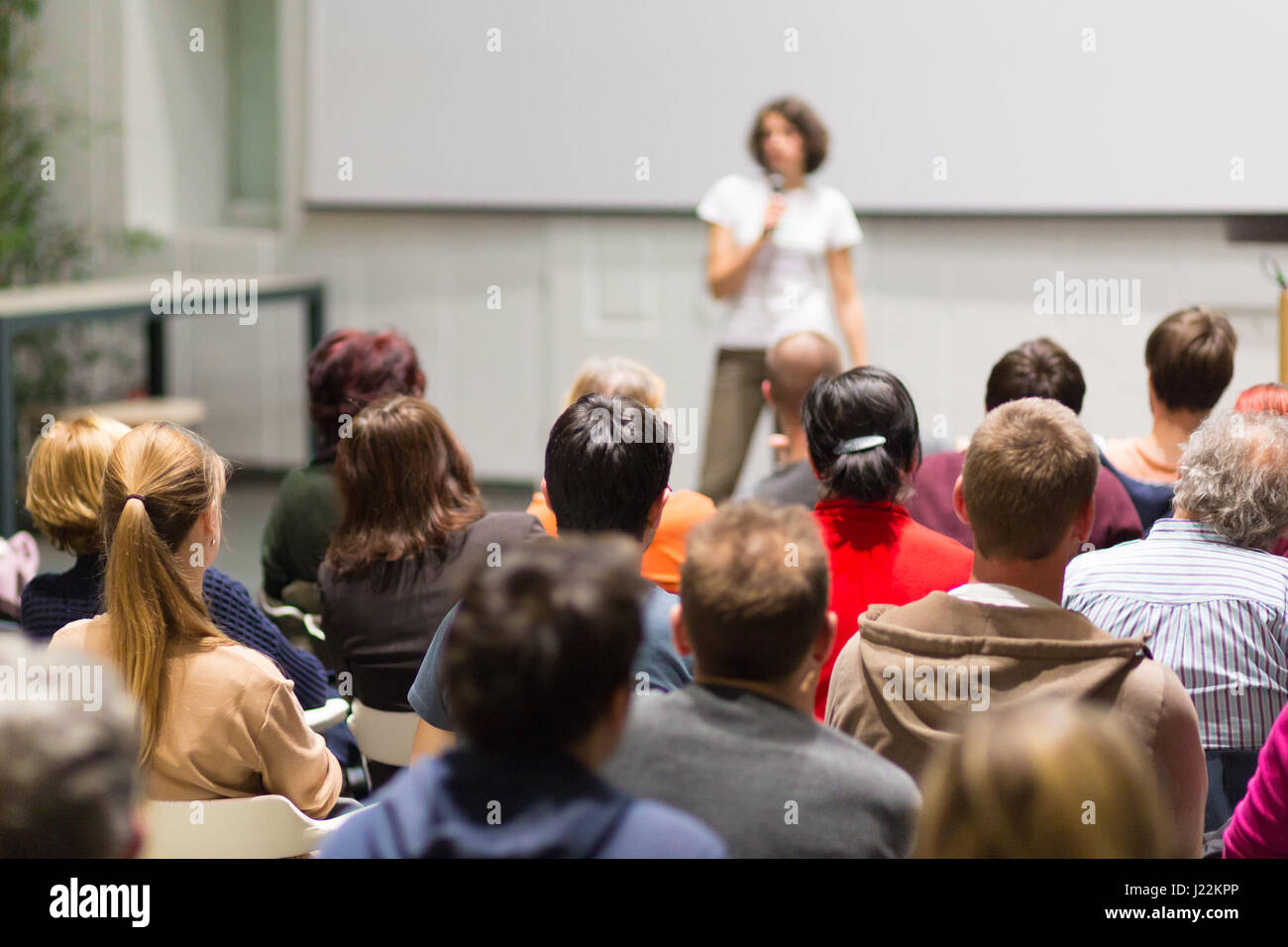 Woman giving presentation in lecture hall at university Stock Photo - Alamy
