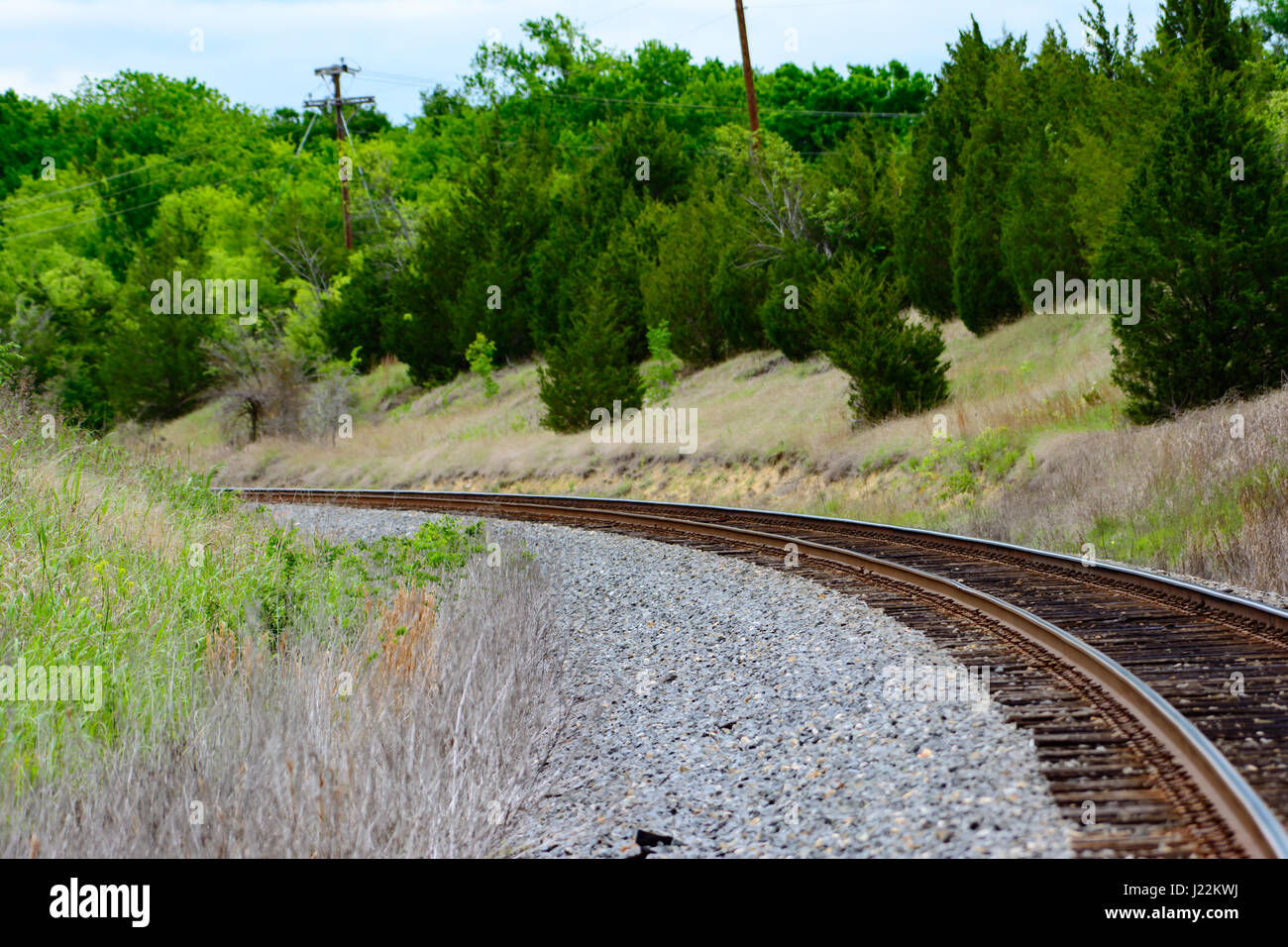 Railroad tracks going downhill and around curve to the left, trees and ...