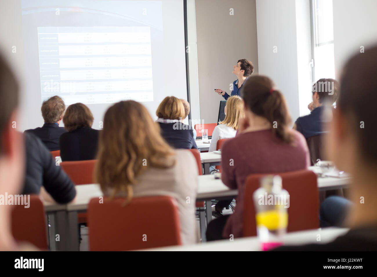 Woman giving presentation in lecture hall at university Stock Photo - Alamy