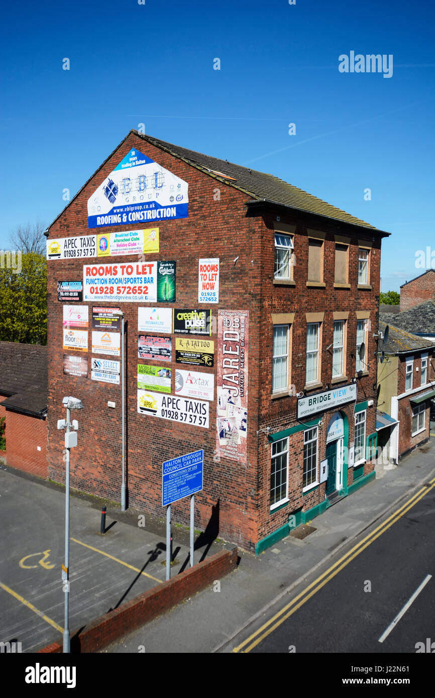 Banners advertising local businesses attached to end wall of a building ...
