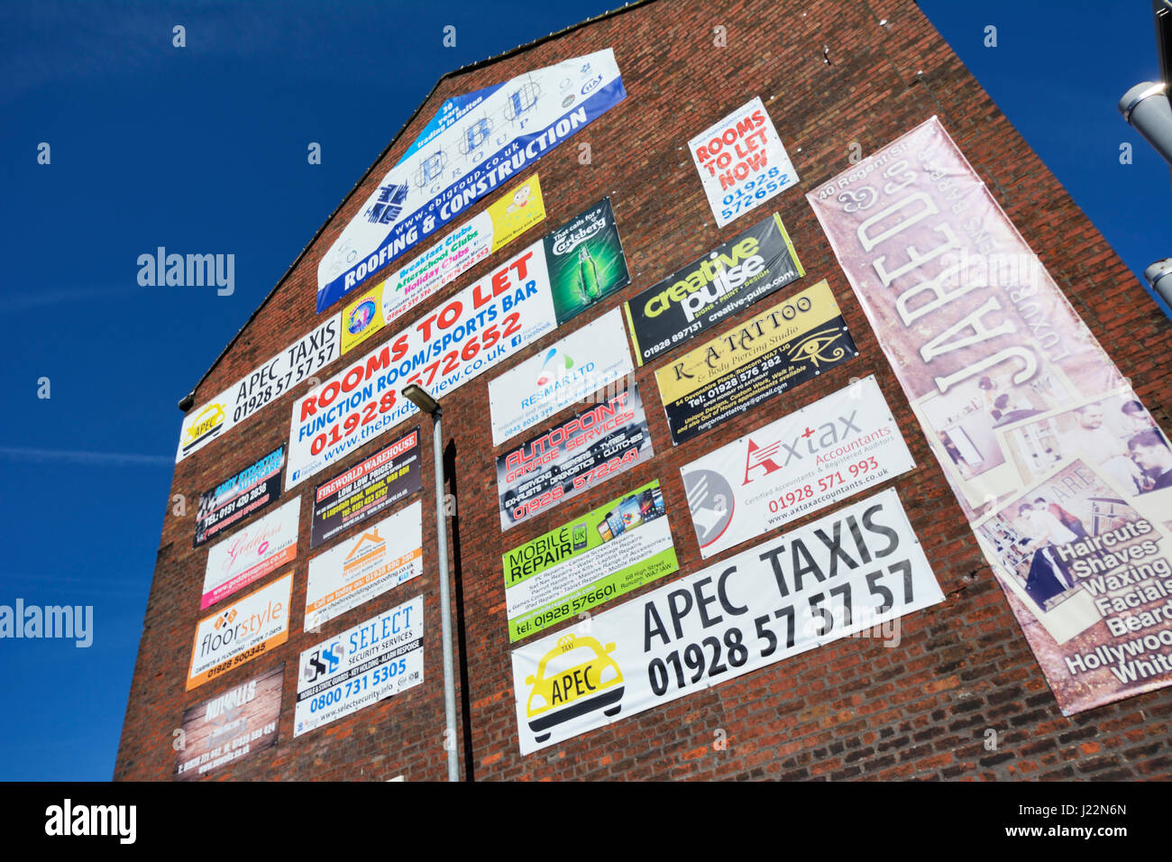 Banners advertising local businesses attached to end wall of a building ...