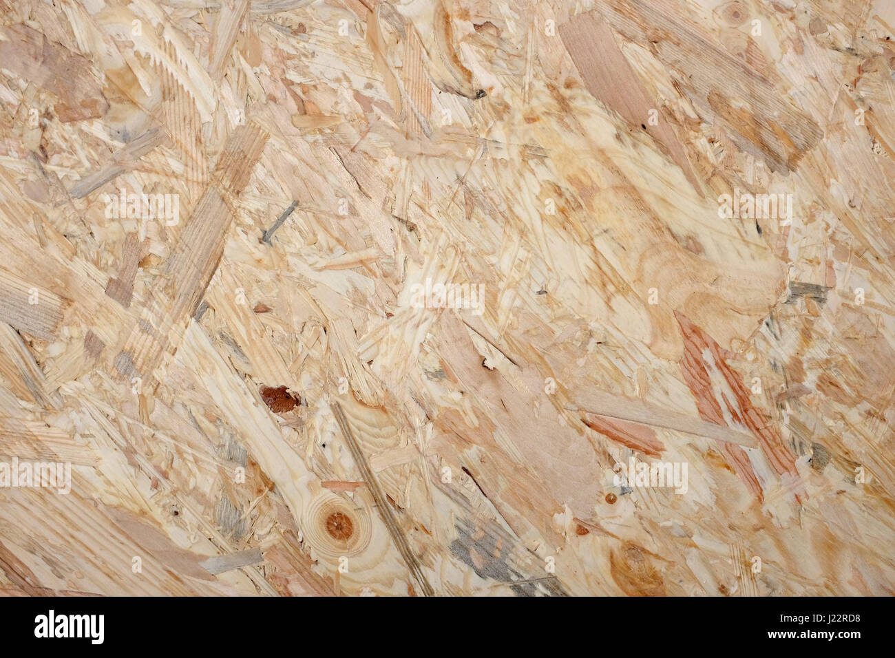 Coarse wooden flakeboard abstract background. Pale OSB sheet with dark ...