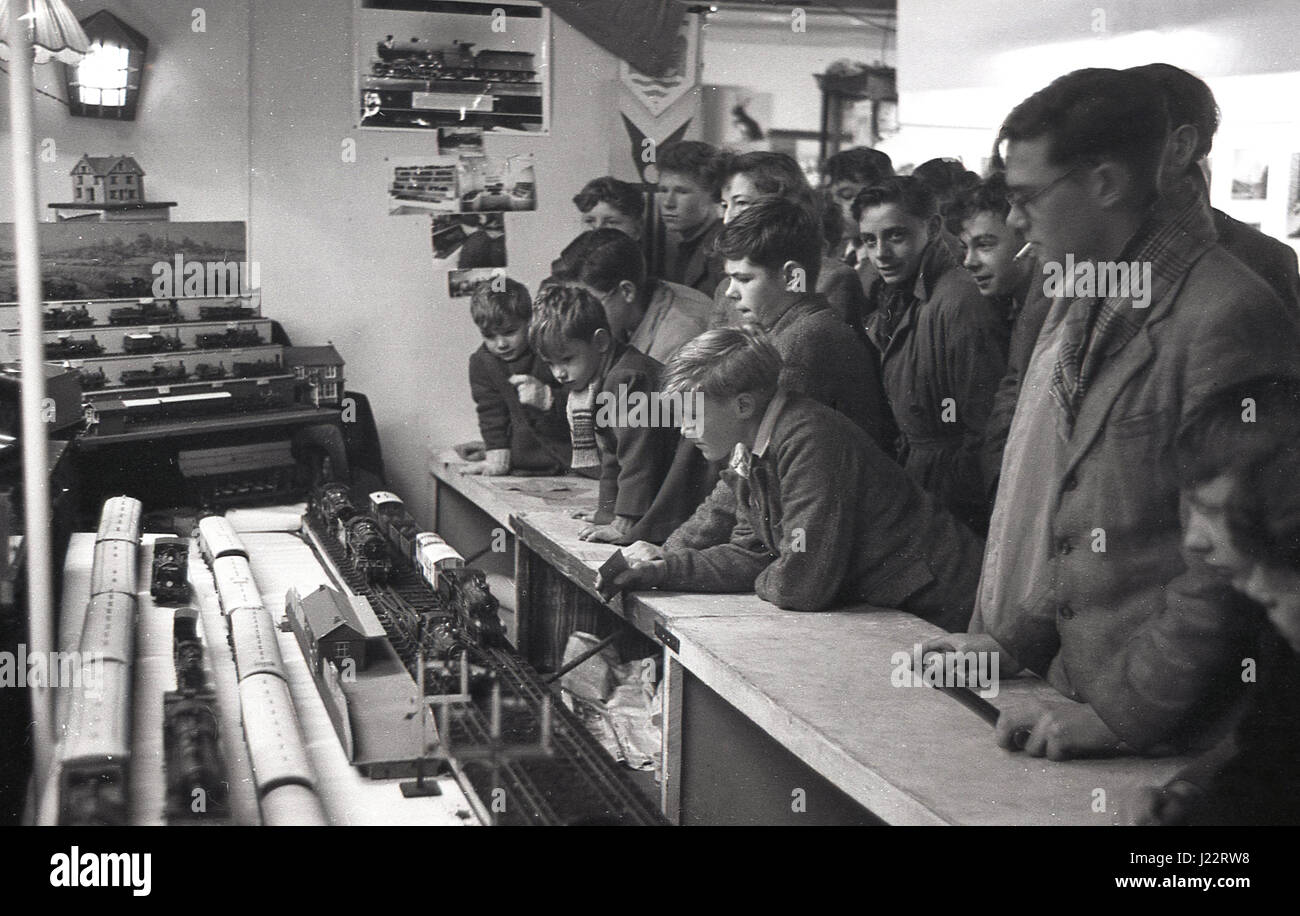 1950s, group of boys and young men study the trains on display at a ...