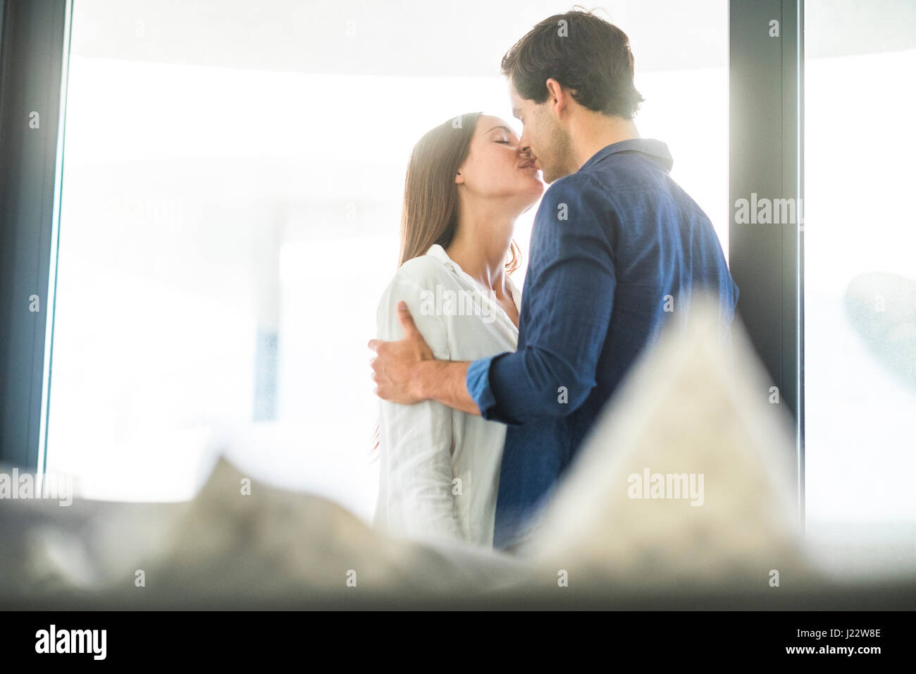 Young couple in love kissing at the window Stock Photo - Alamy
