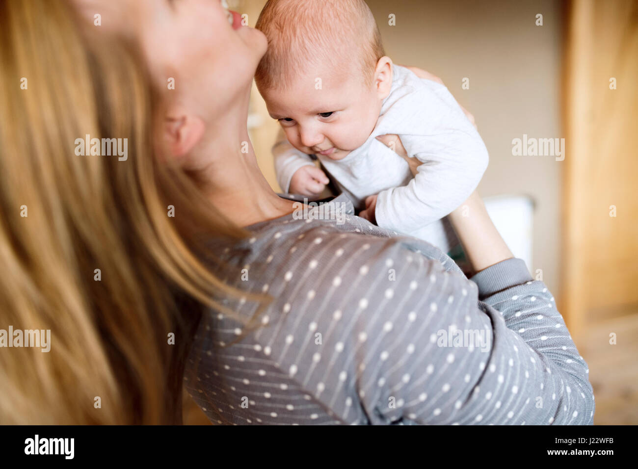 Happy mother holding baby at home Stock Photo - Alamy