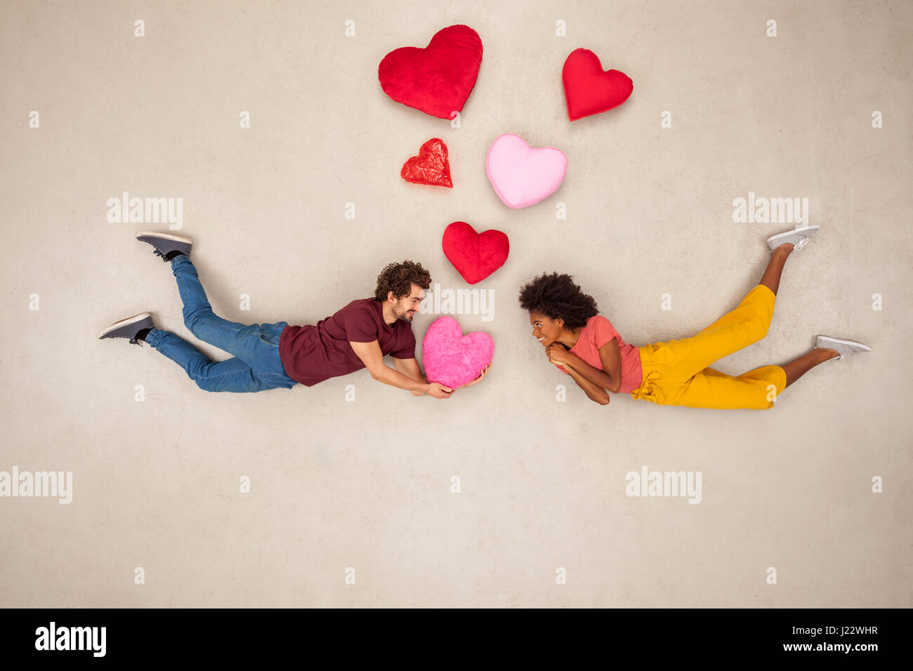 Happy couple flying with hearts around Stock Photo - Alamy