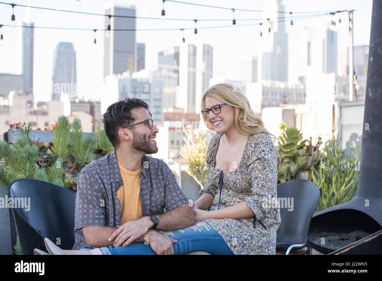 Couple sitting on rooftop terrace Stock Photo - Alamy