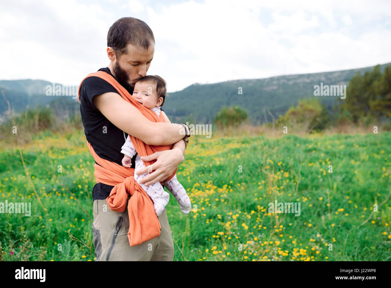 Father carrying baby girl outdoors in a baby sling Stock Photo - Alamy