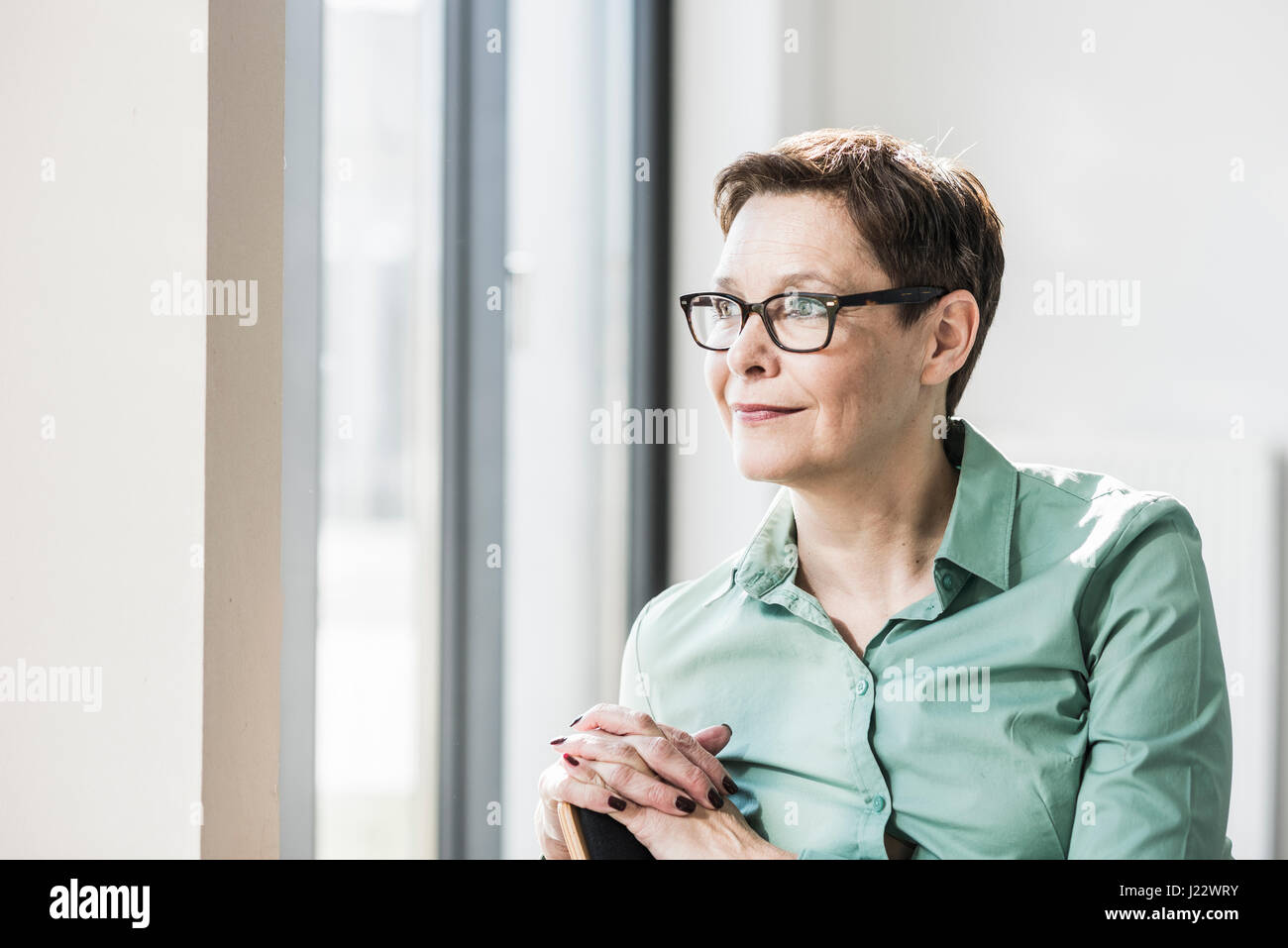 Confident businesswoman with glasses looking sideways Stock Photo - Alamy
