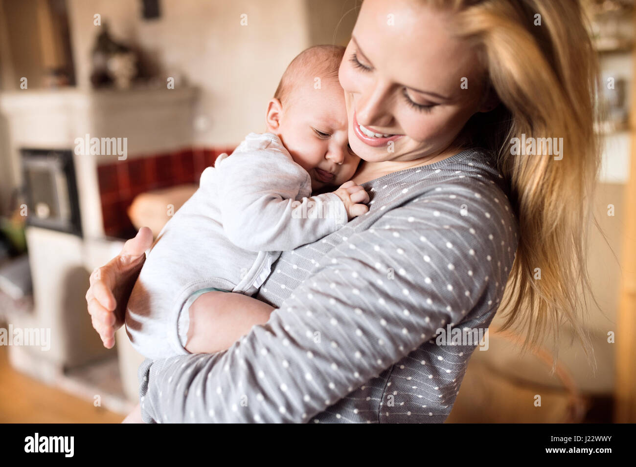 Happy mother holding baby at home Stock Photo - Alamy