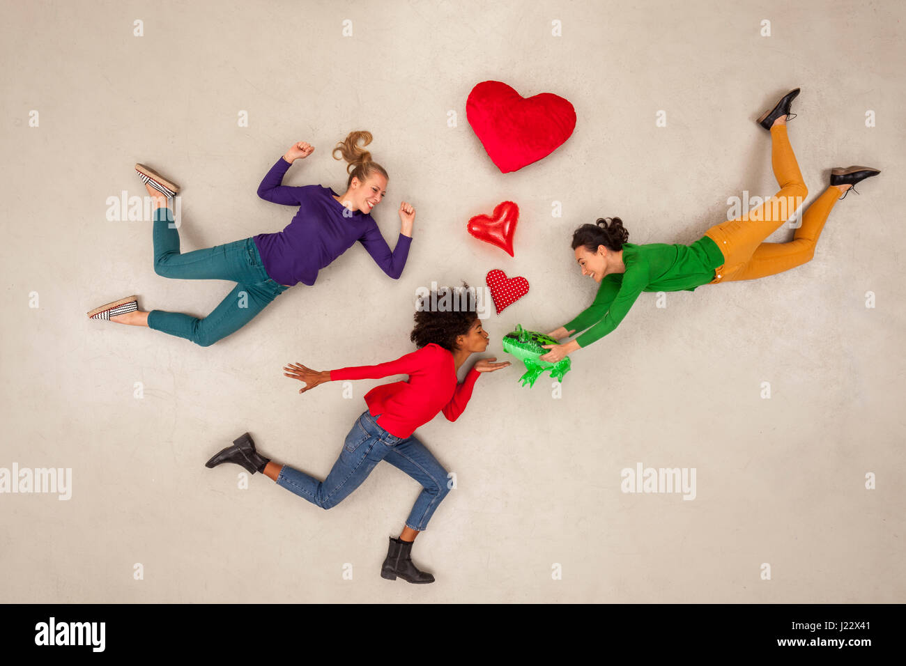 Three friends making one kissing a frog Stock Photo - Alamy