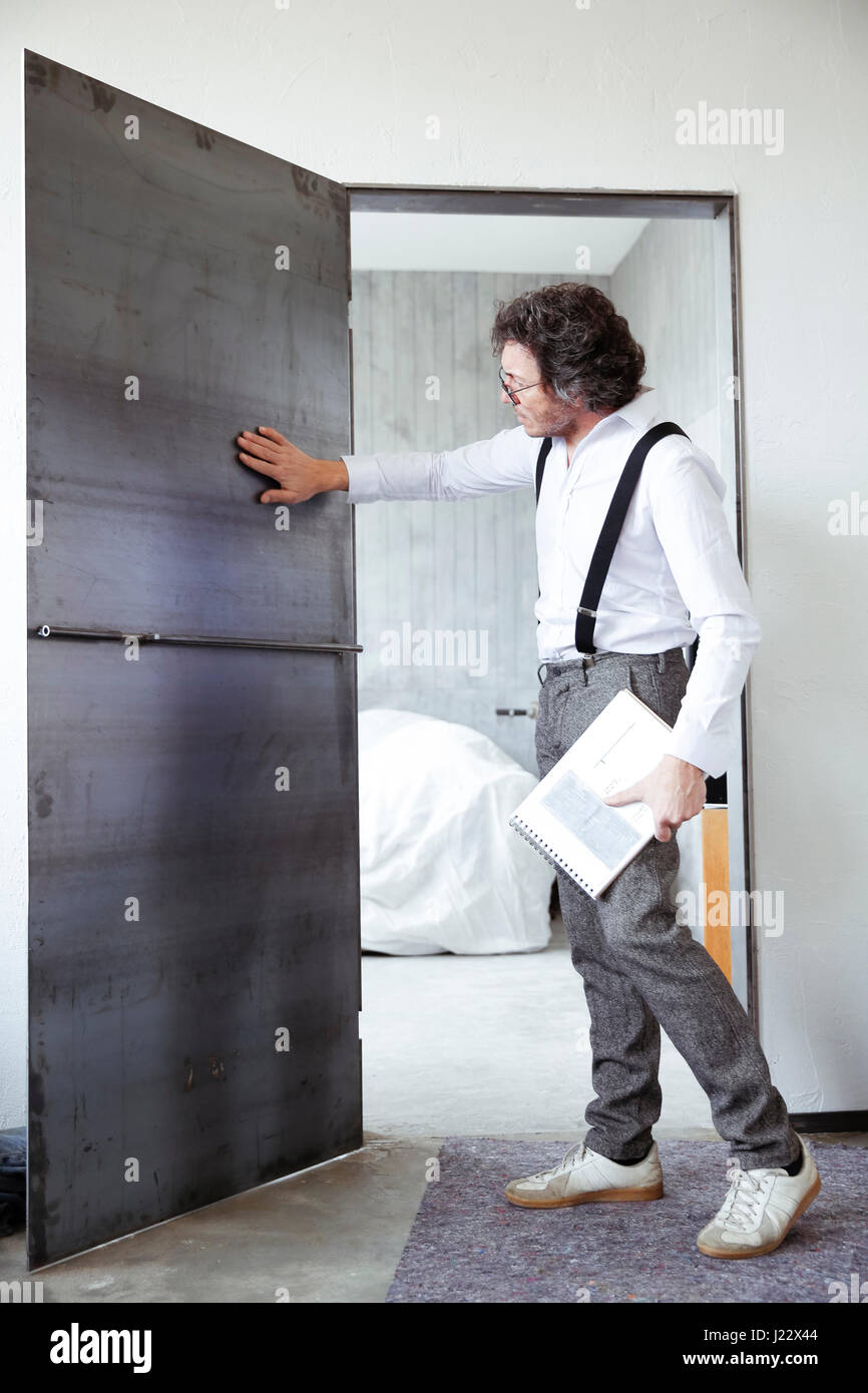Architect checking steel door at construction site Stock Photo - Alamy