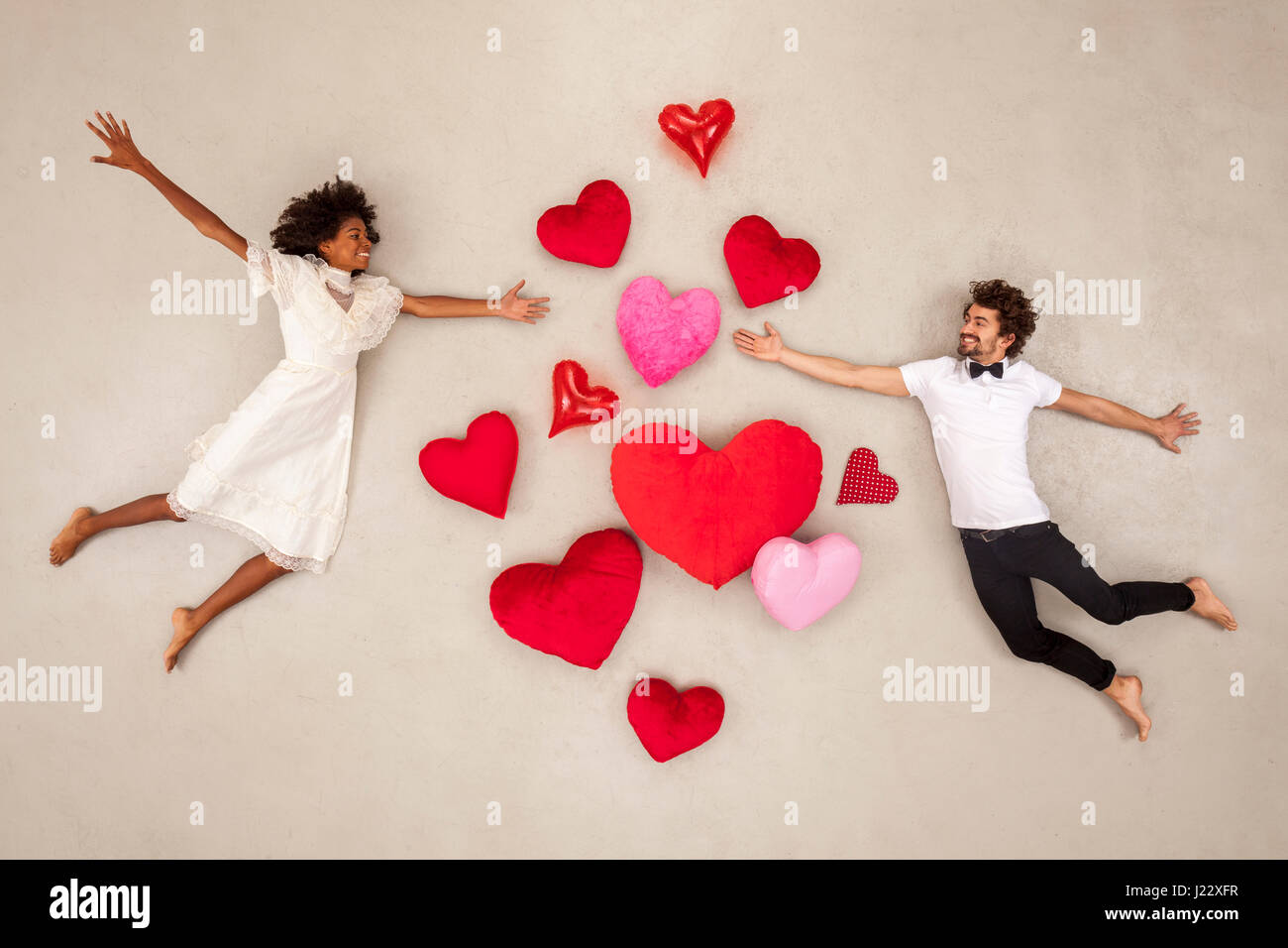 Young couple falling in love with hearts around Stock Photo - Alamy