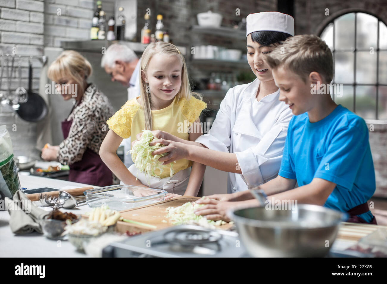 Female chef instructing kids in cooking class Stock Photo - Alamy
