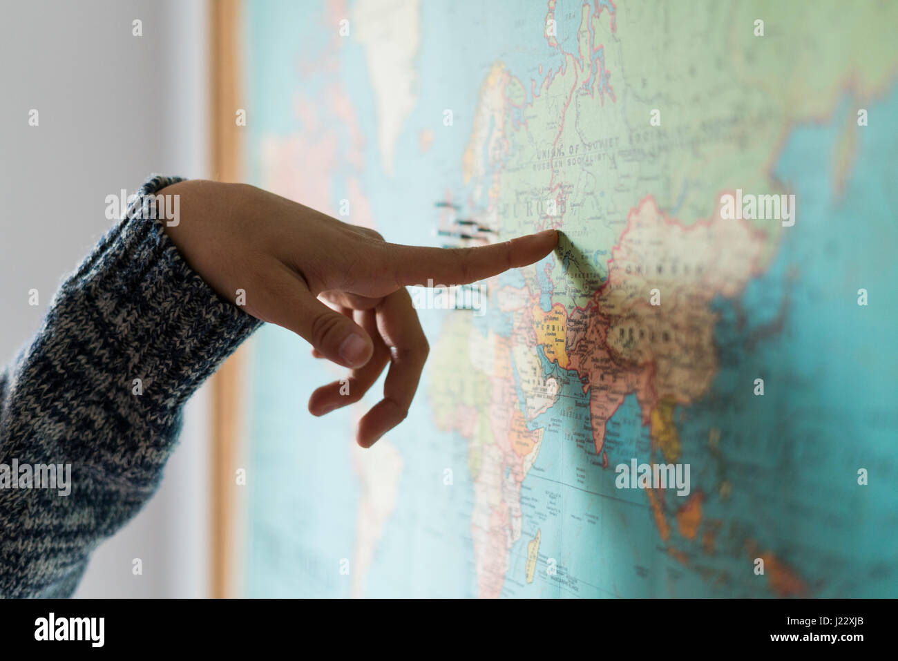 Woman's hand pointing on world map Stock Photo - Alamy