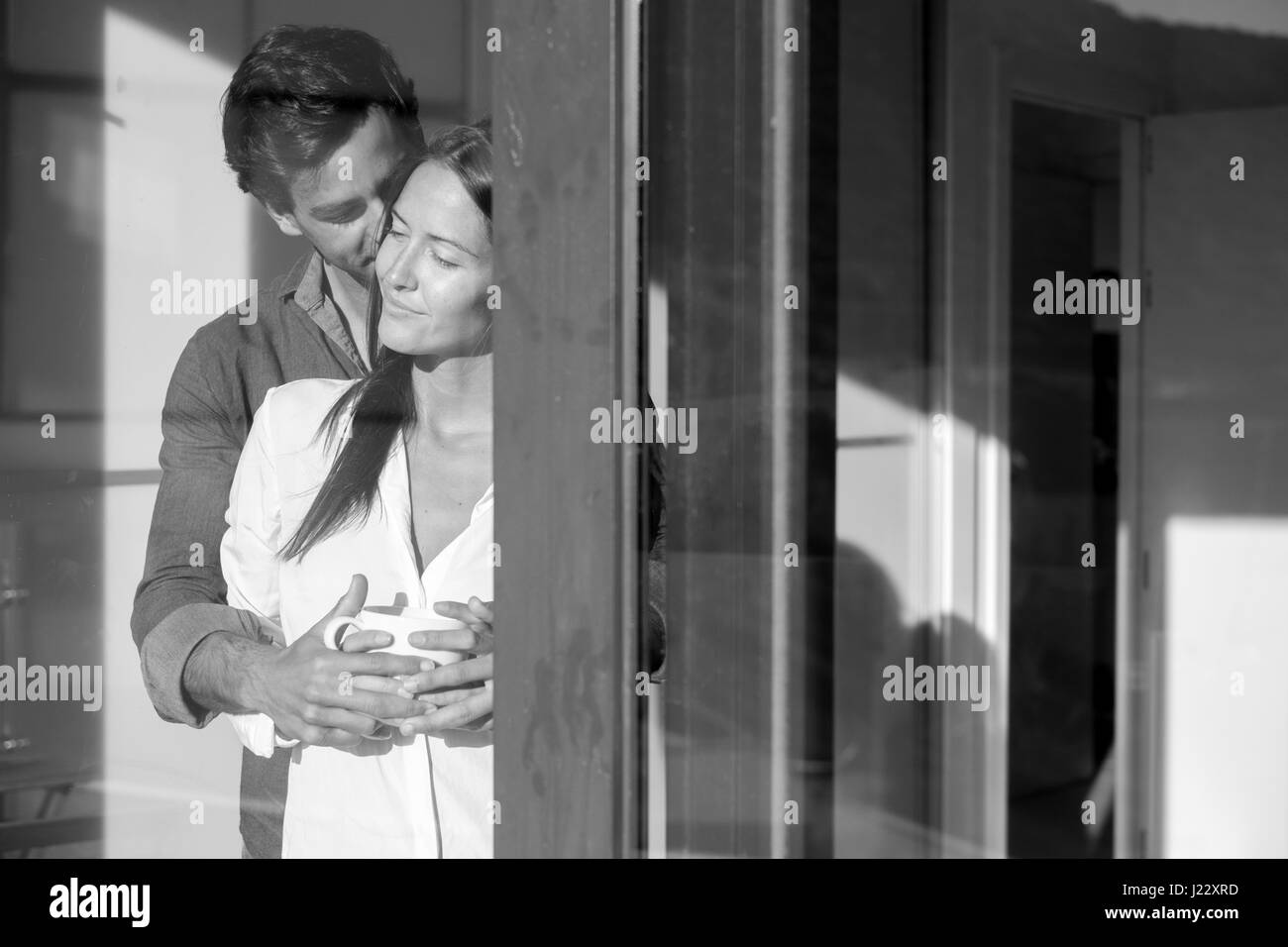 Young couple in love at the window Stock Photo - Alamy