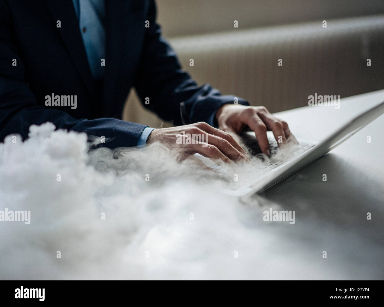 Close-up of businessman using smoking laptop in office Stock Photo - Alamy