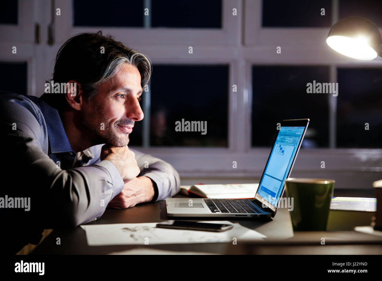 Man working late in office Stock Photo - Alamy