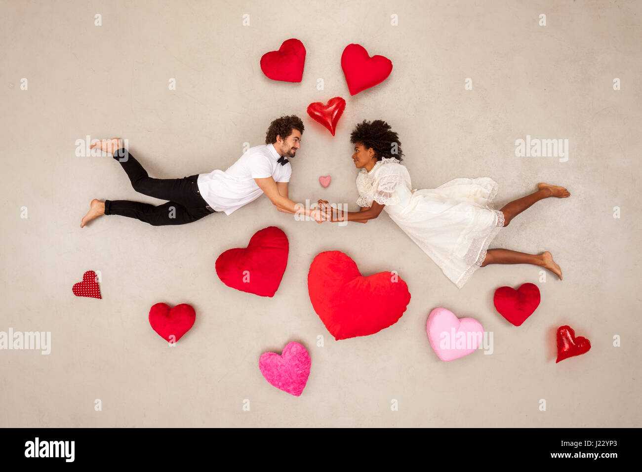 Young couple falling in love with hearts around Stock Photo - Alamy