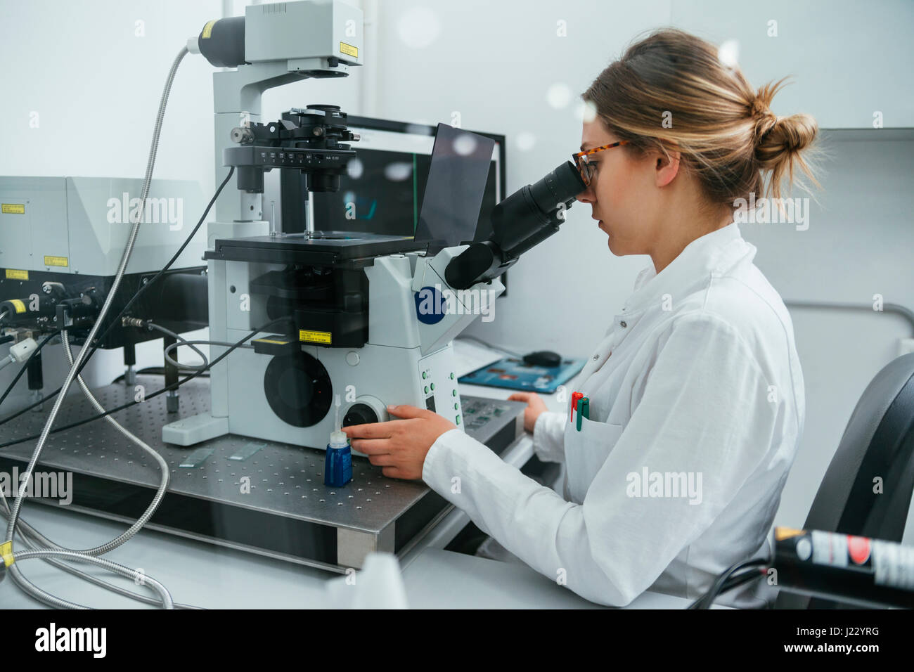 Sitting microscope research scrutiny concentration hi-res stock ...