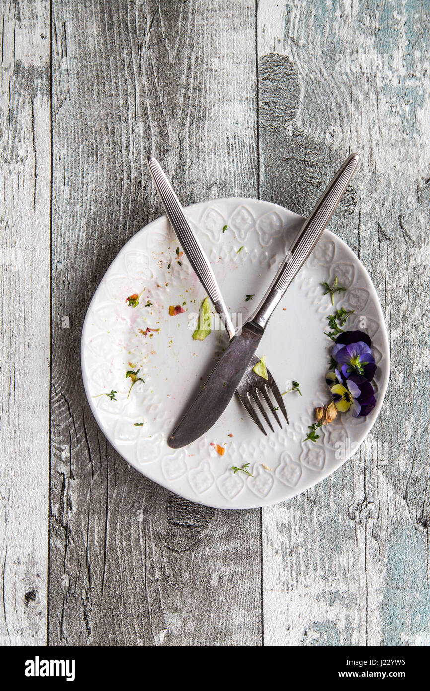 Plate with cutlery and remains of dish Stock Photo - Alamy