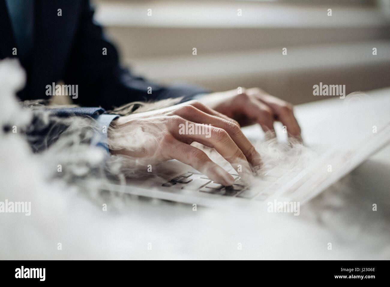 Close-up of businessman using smoking laptop in office Stock Photo - Alamy
