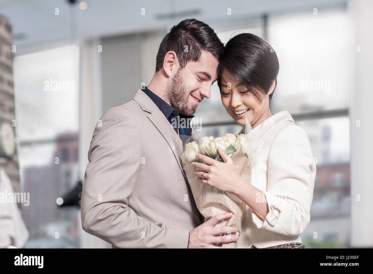 Man handing over roses to woman at home Stock Photo - Alamy