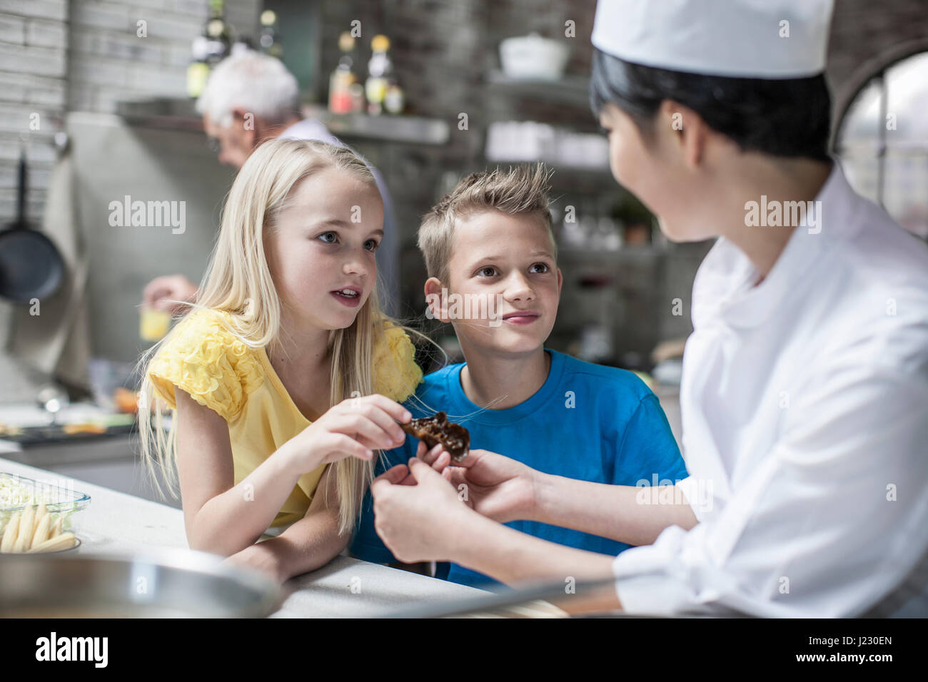 Boy and girl asking questions in cooking class Stock Photo - Alamy